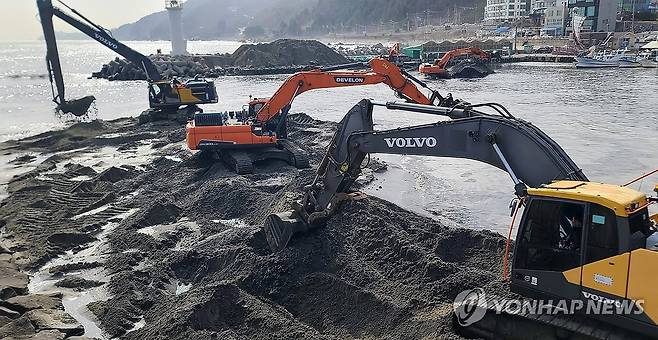 항 내에 쌓인 모래 퍼내는 굴착기