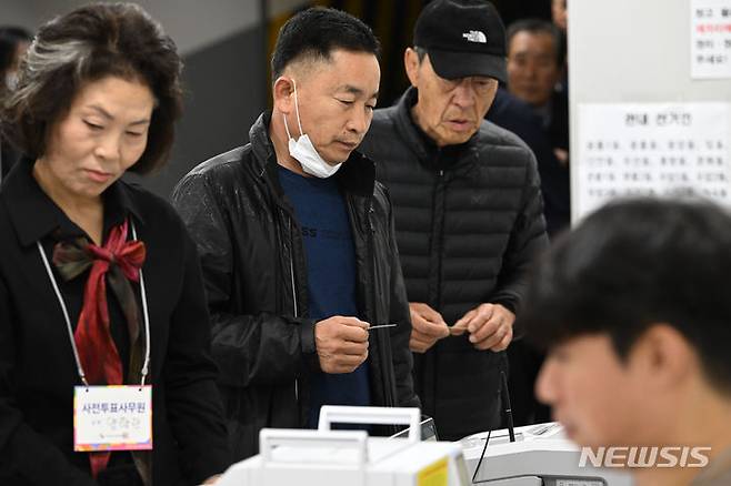 투표 용지 기다리는 유권자